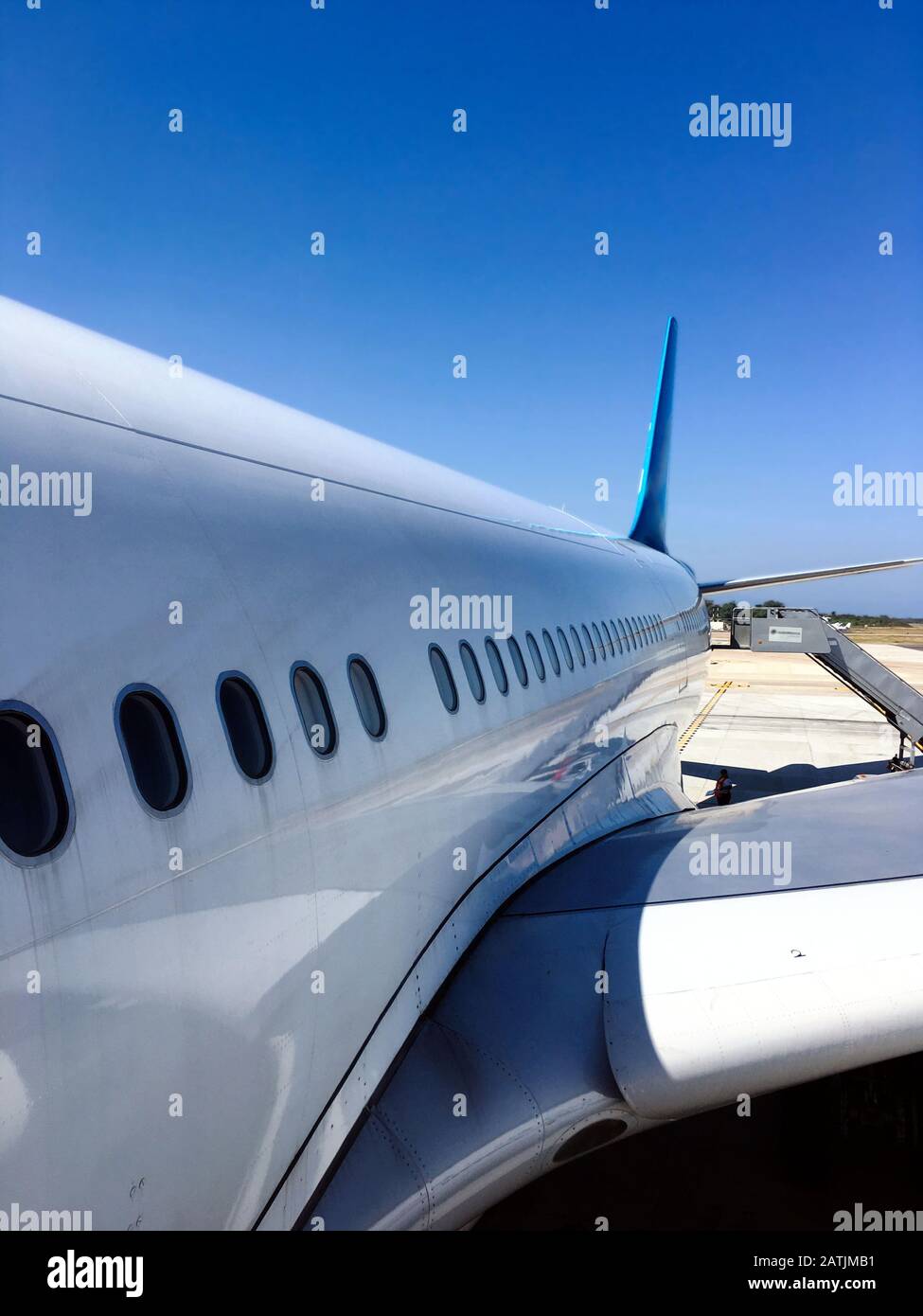 side view of white passenger airplane with oval windows. diminishing ...