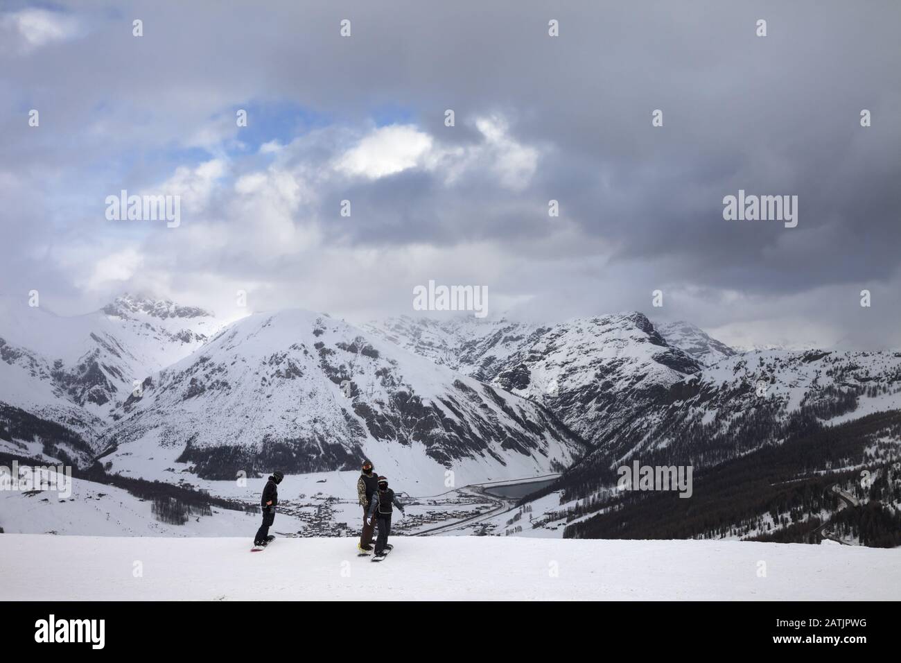 Group of snowboarders starts on off-piste descent. High snowy mountains ...