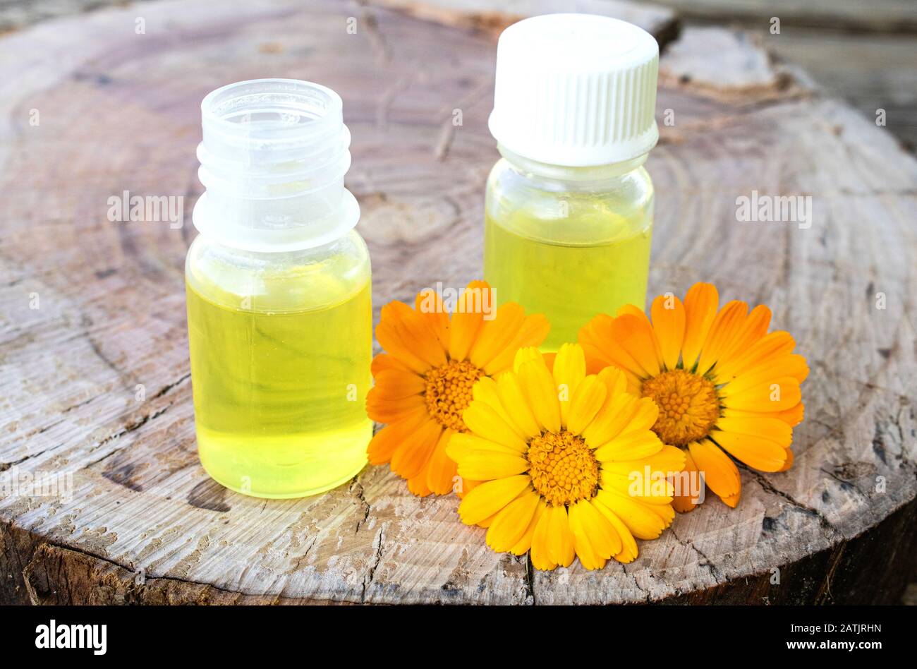 Bottle of calendula oil on a wooden background. Extract of tincture of ...