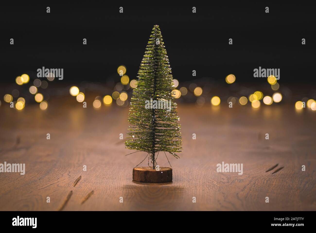Christmas tree decoration on a wooden surface with golden bokeh lights ...