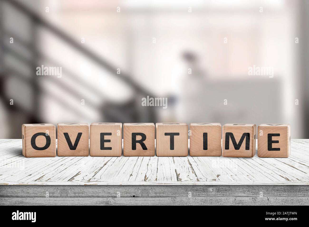 Overtime word spelled with wooden blocks in an office environment Stock ...