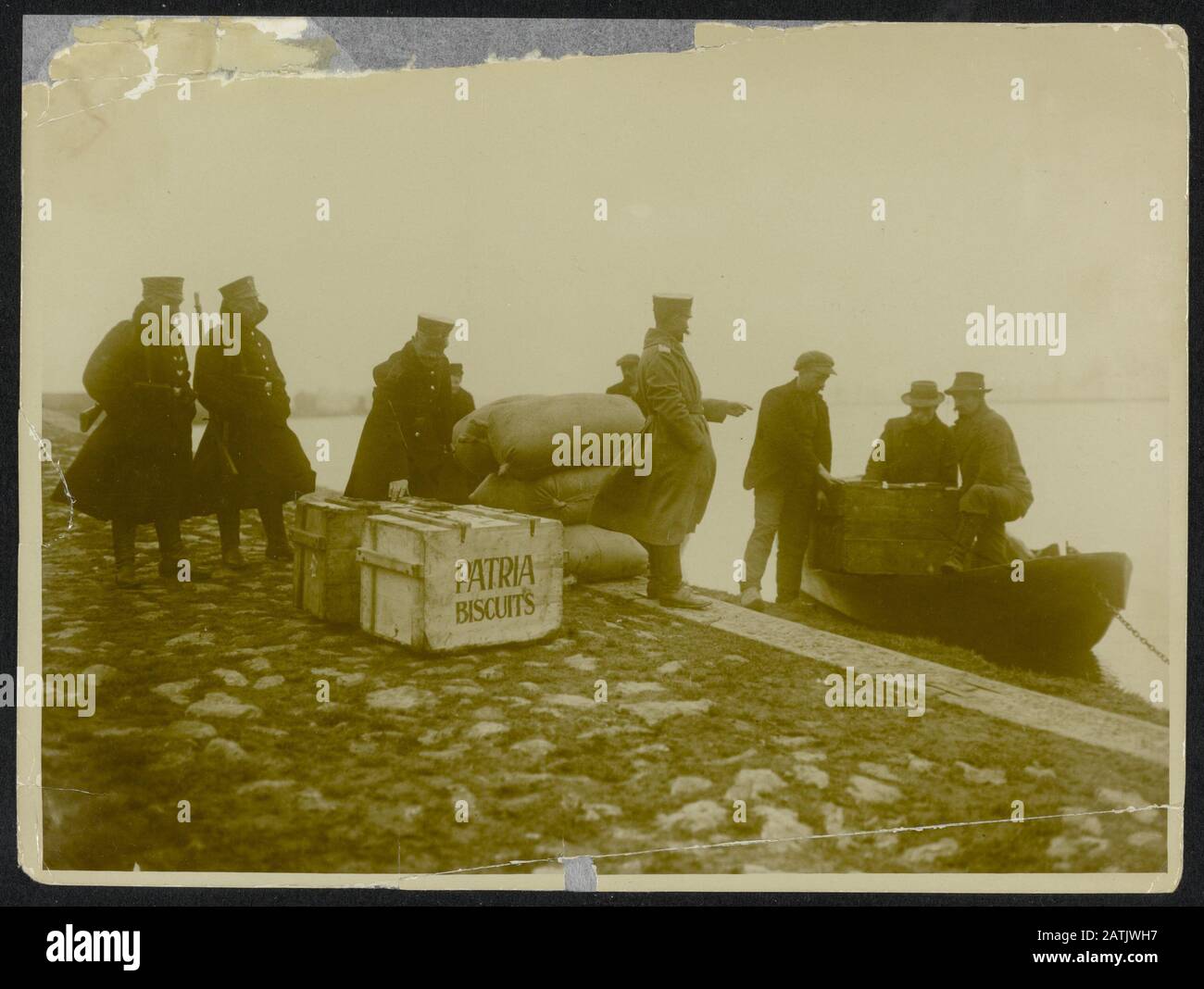 Description: Armed soldiers monitor citizens discharging a sloop ...