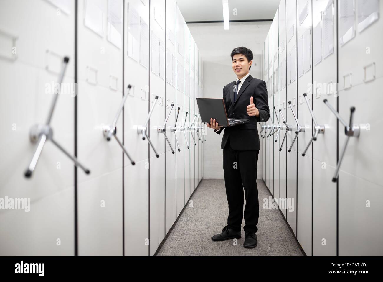 Business man, bank manager using notebook in a locker server room, safe ...