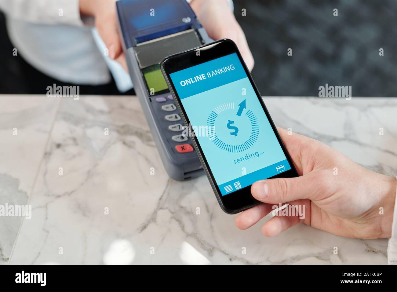 Above view of unrecognizable customer putting smartphone to terminal ...