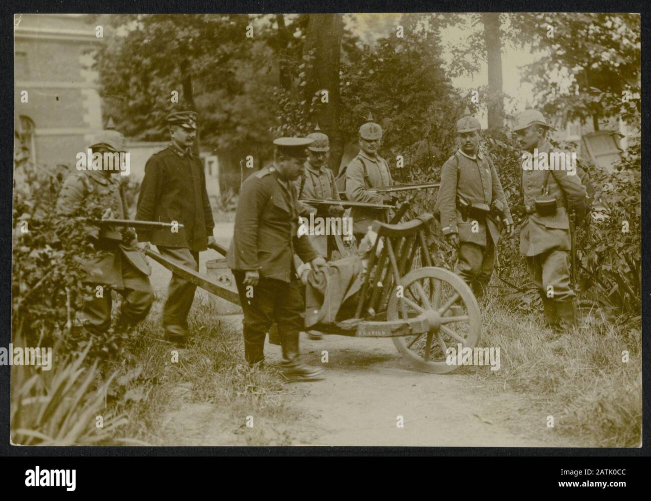Description: German soldiers carry a wounded soldier on a wheelbarrow ...