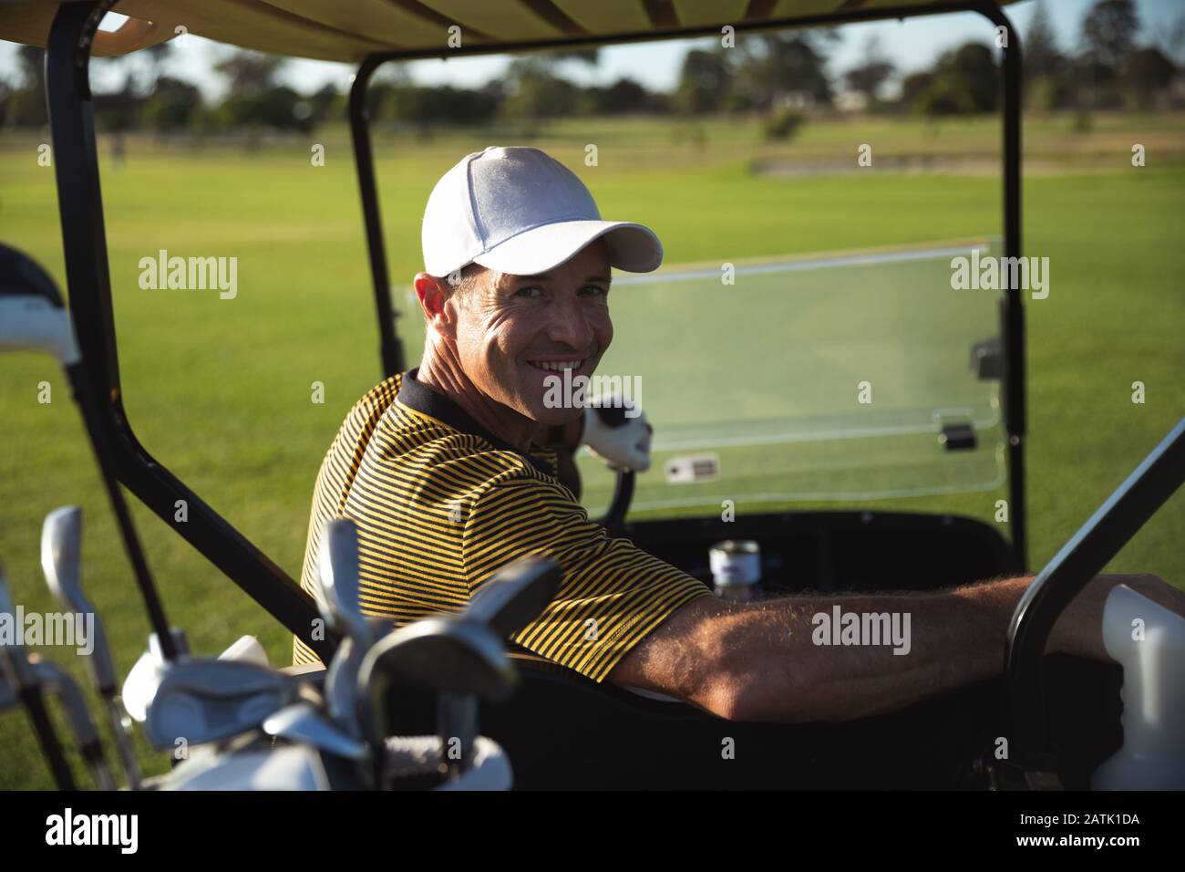 Golfer sitting in golf buggy Stock Photo - Alamy