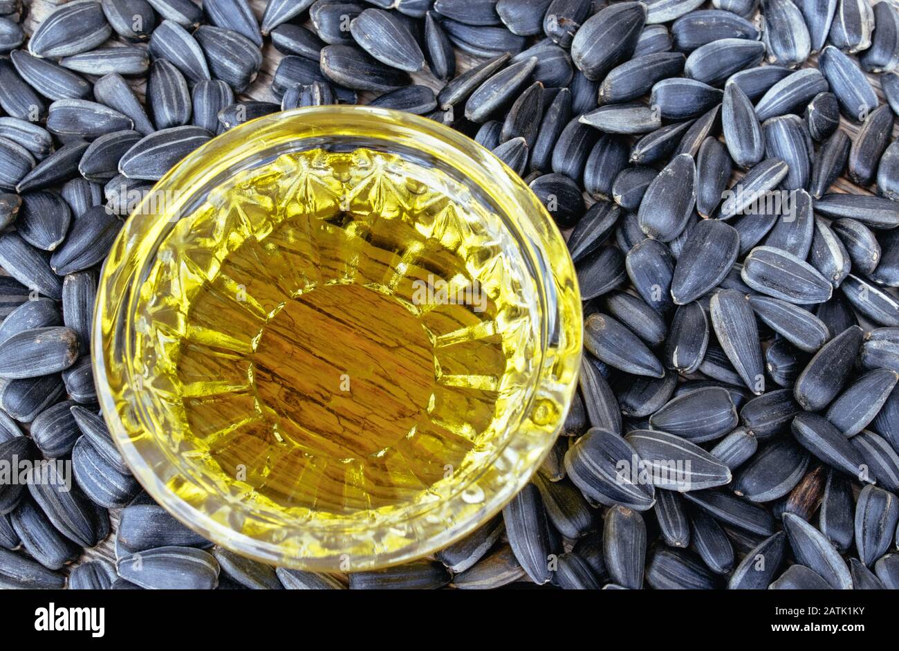 Sunflower oil and sunflower seeds on a wooden background. Healthy foods ...
