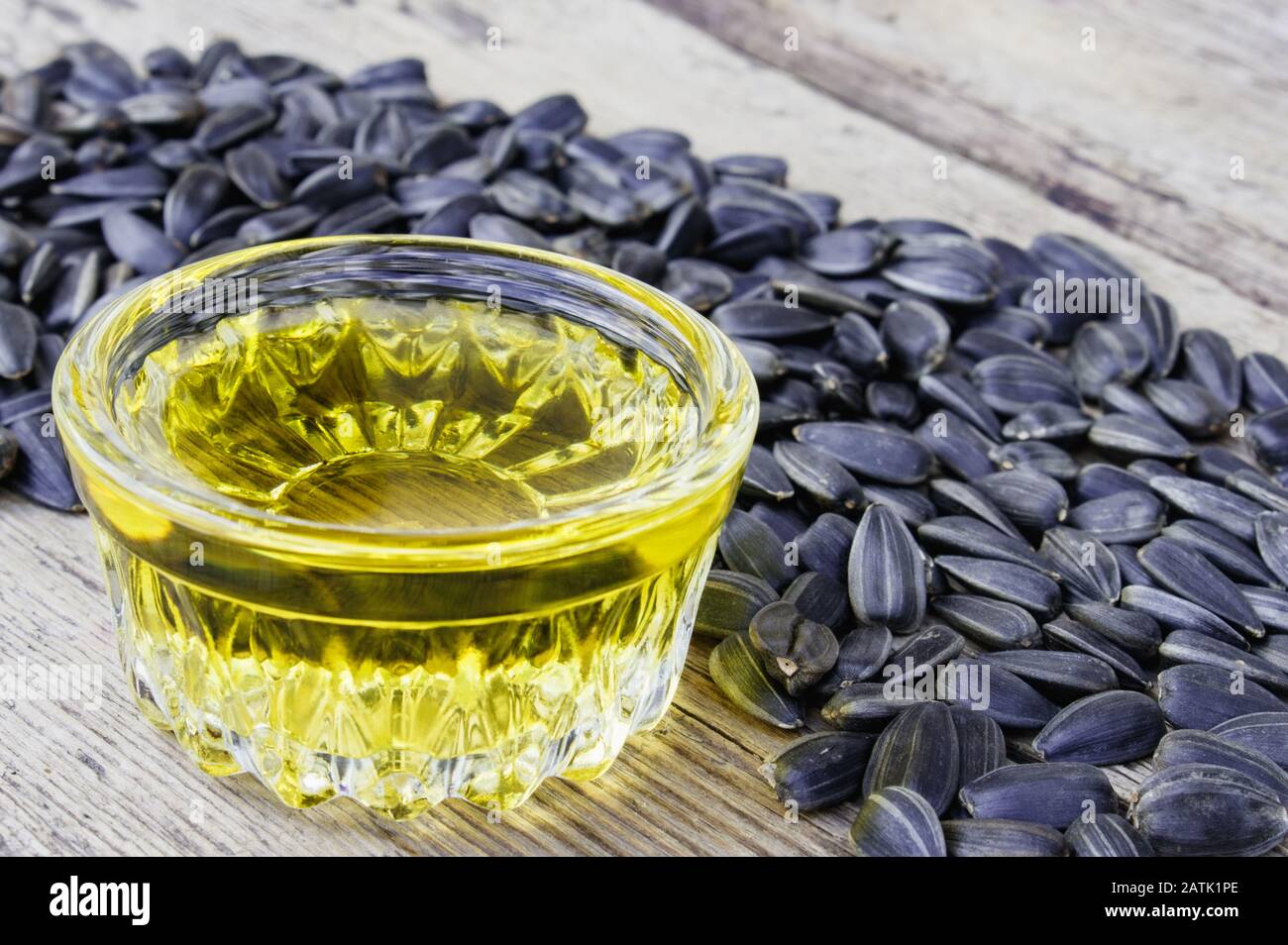 Sunflower oil and sunflower seeds on a wooden background. Healthy foods ...