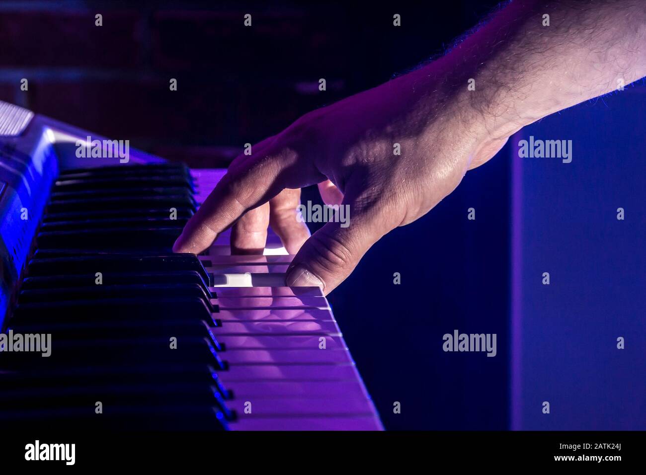 A close up concert scene of a male musician's hand playing a chord on a ...