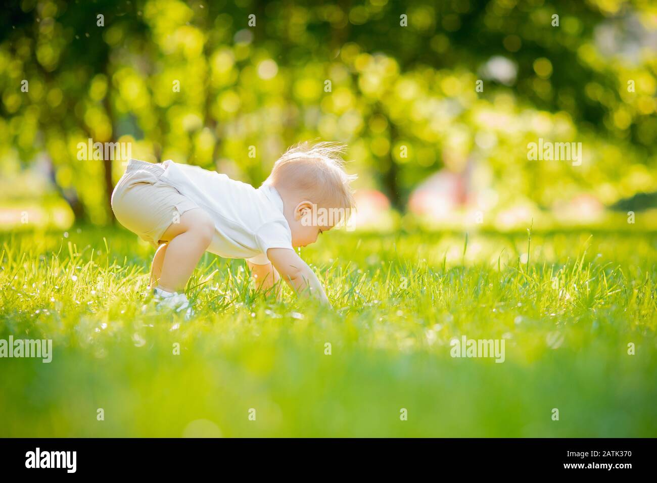 Portrait child boy crawling takes first step, trying to stand up in ...