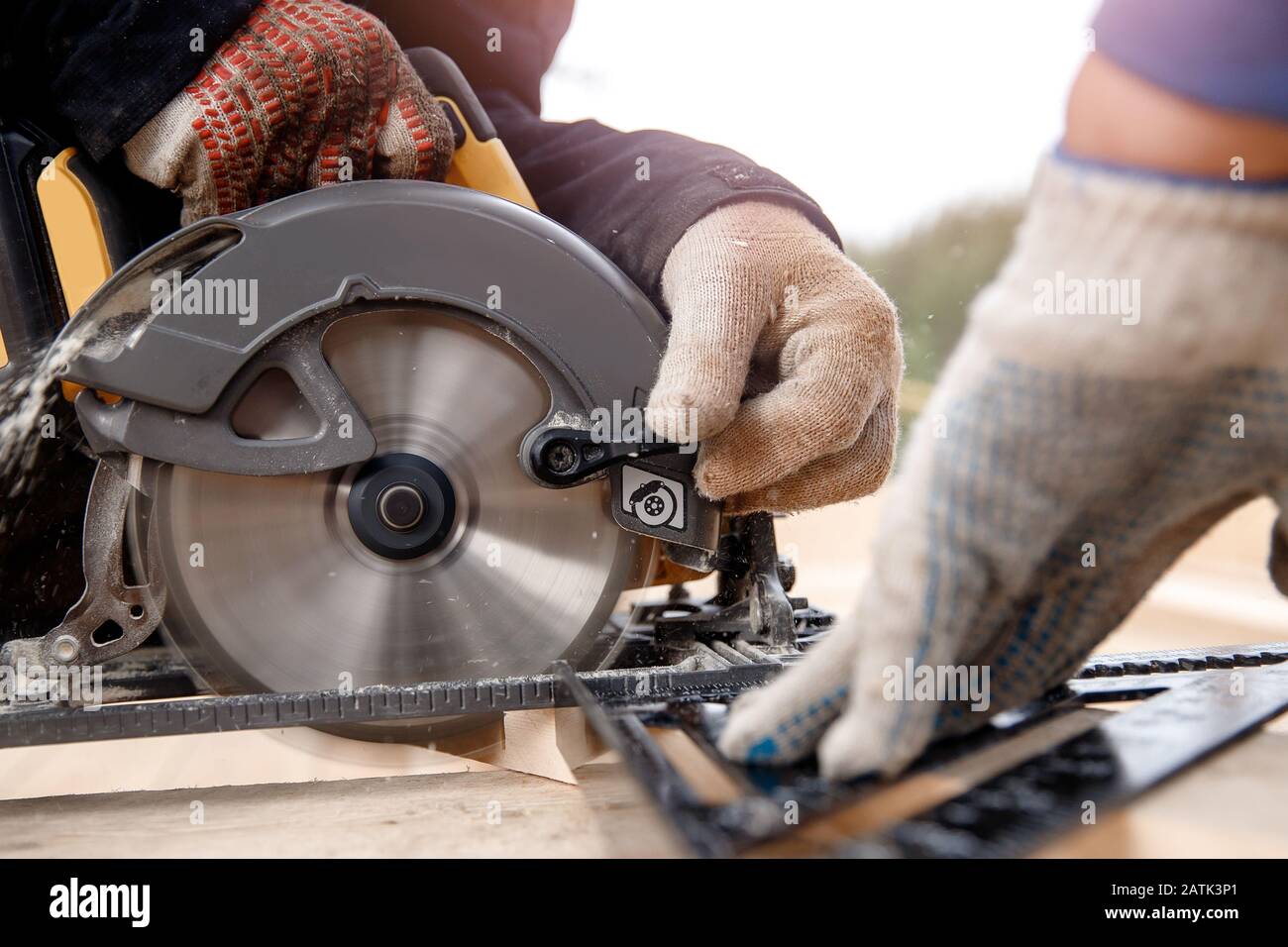 Builder uses portable circular saw tool to cut wood Stock Photo - Alamy