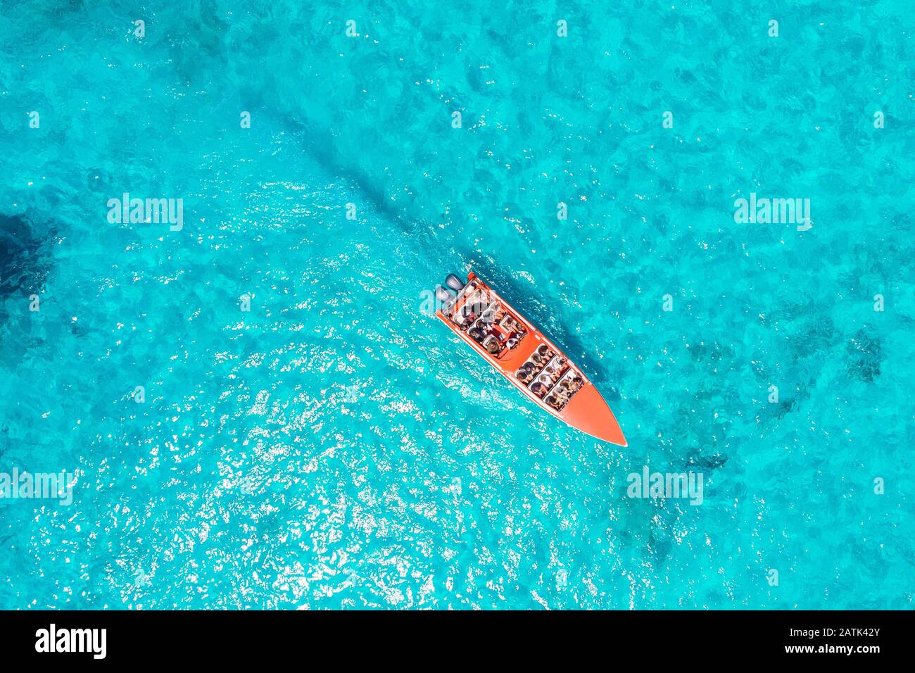 Pleasure Speedboat sailing on blue clear water of large coral reef with ...