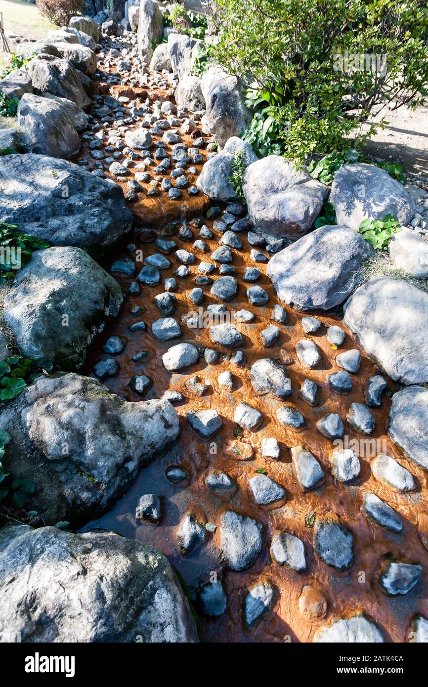 Hot spring (Jigoku), multi-colored volcanic creek with stones in ...
