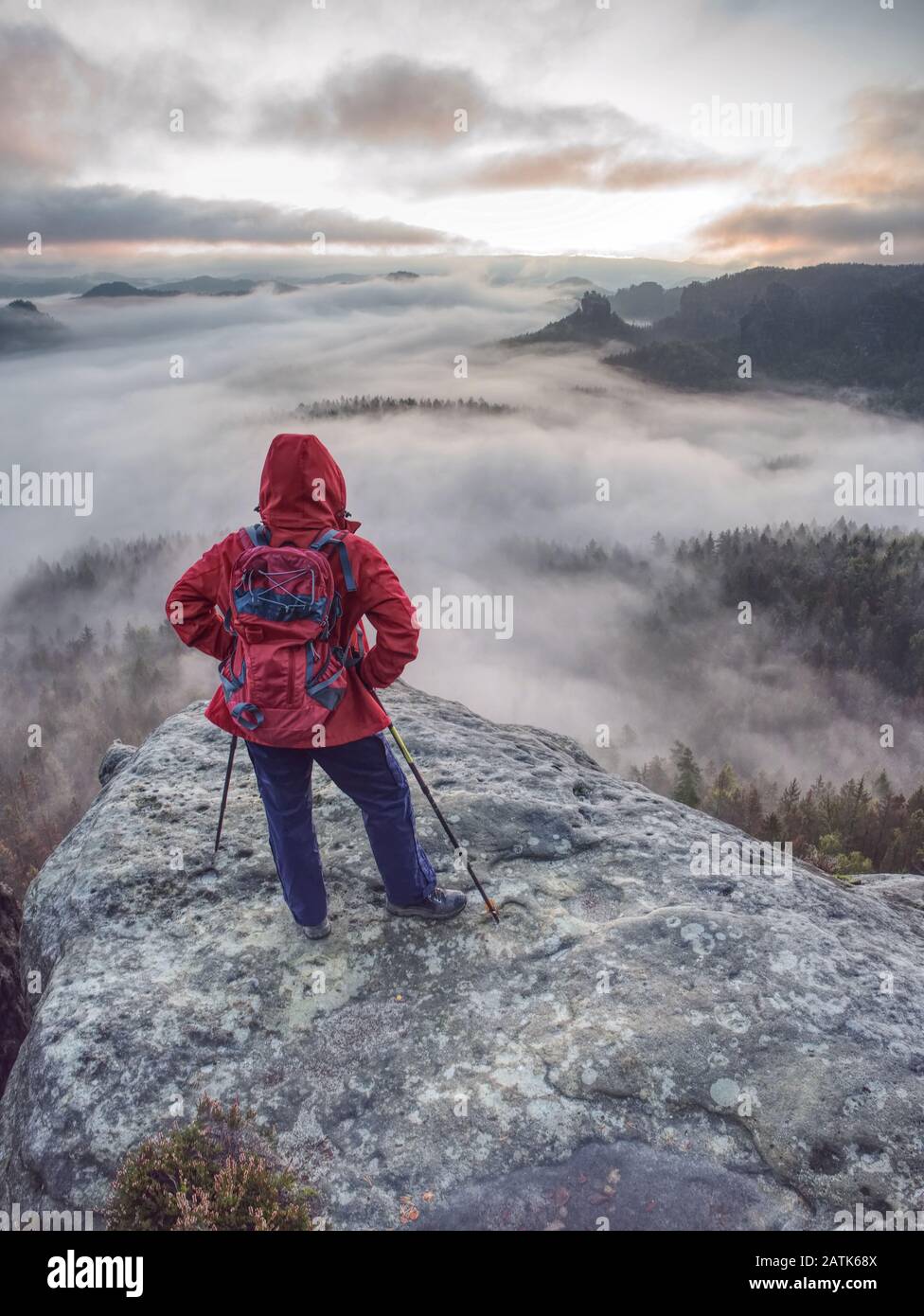 Woman hiker stop at the end of path on the edge. View from sharp cliff ...