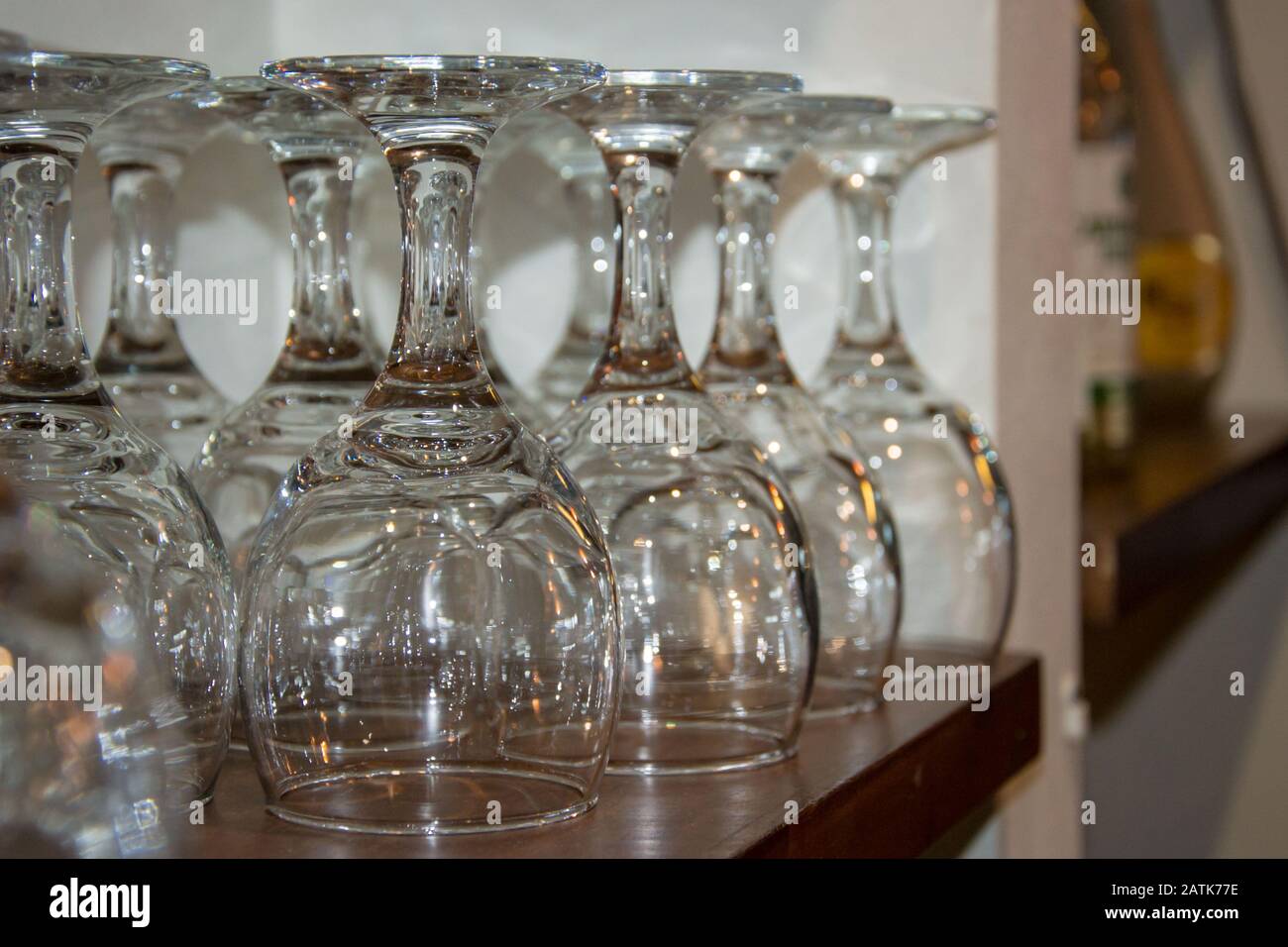 Stack of cleaned glasses on bar counter, wooden shelf, service at hotel ...