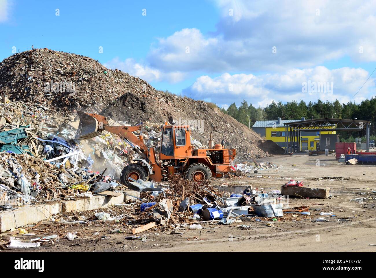 Front-end loader works in a landfill for the disposal of construction ...
