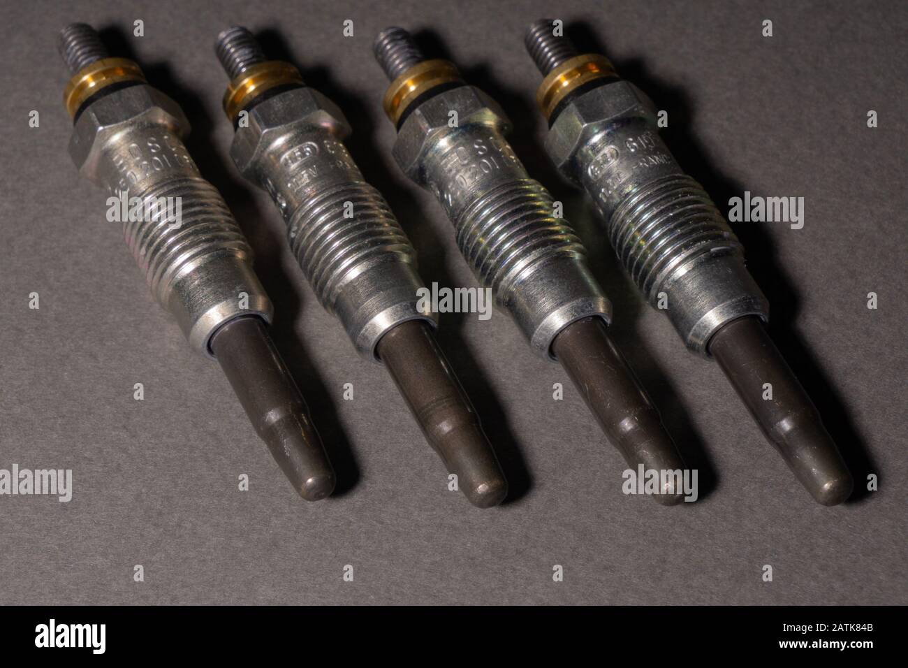 Diesel engine glow plug on a gray background. Replaceable part of a ...