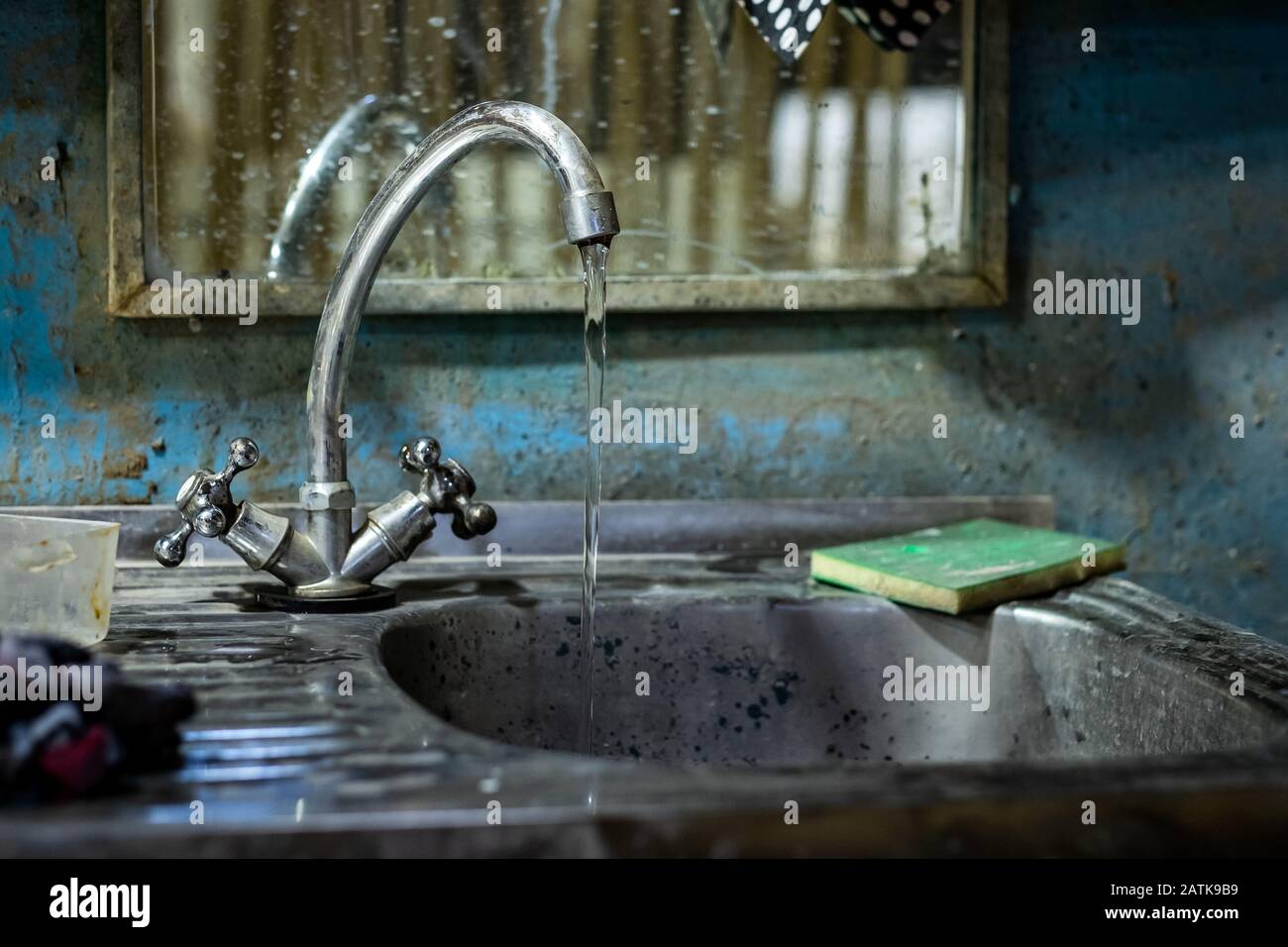 View on dirty little wash basin for hands. rusty water flows from the ...