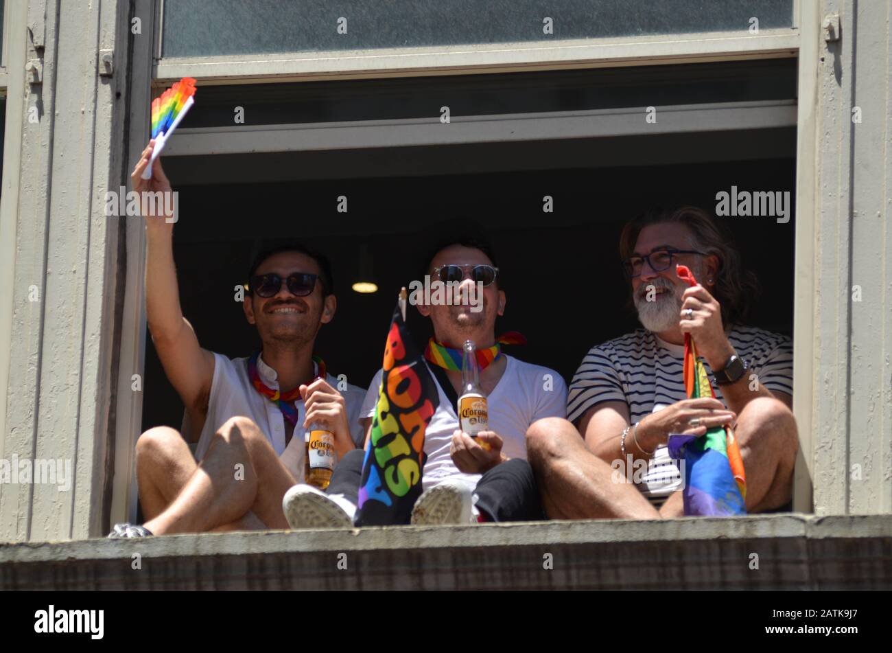 People are seen sitting on their window to enjoy the colorful pride ...