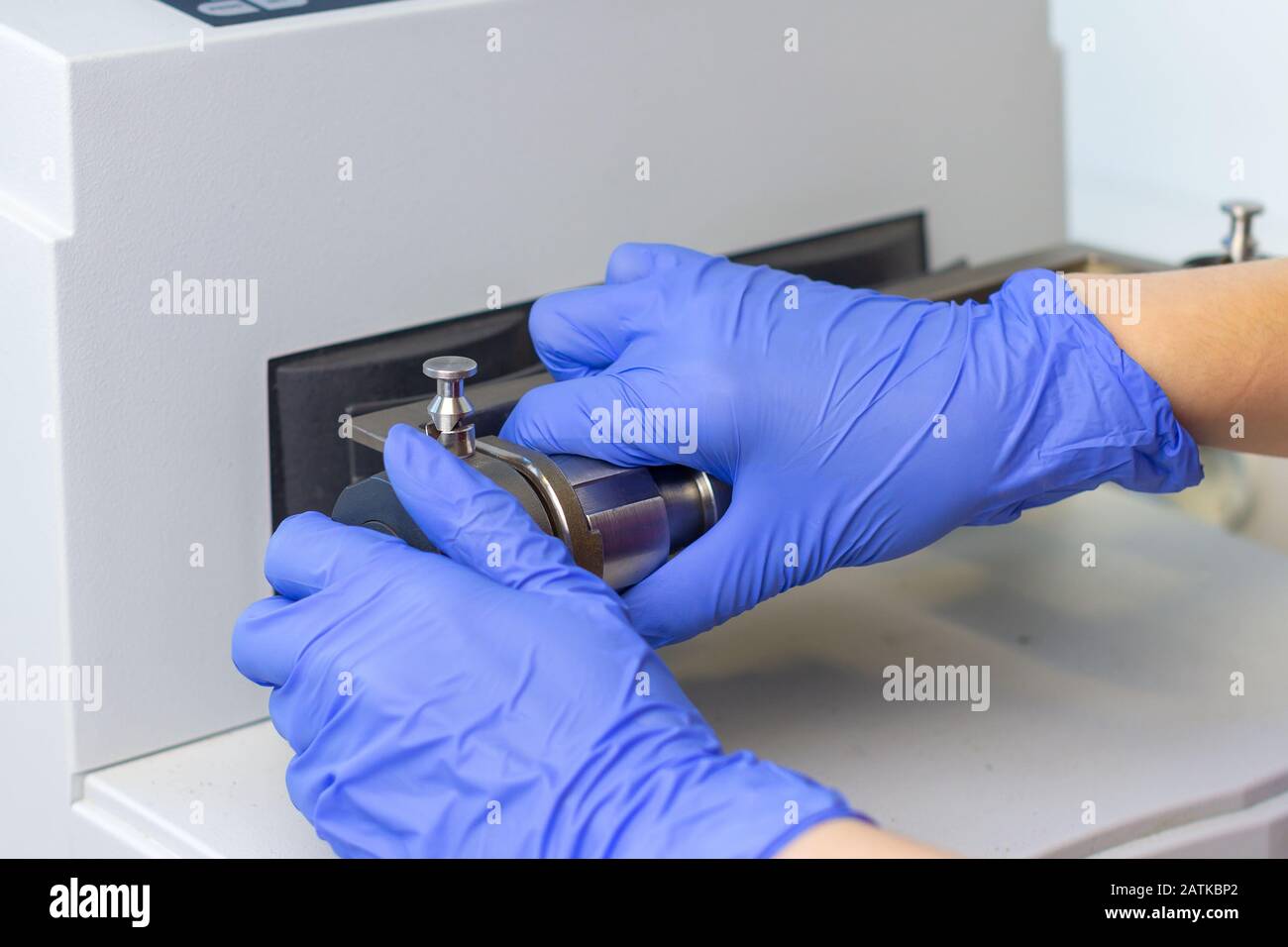 Preparation of sample using vibrating mill. Woman hands in blue gloves ...