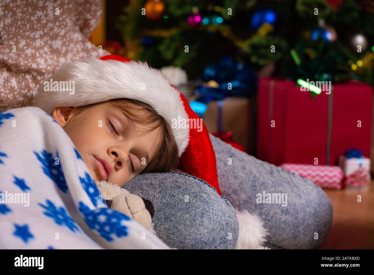 Girl fell asleep on mom's lap on New Year's Eve, close-up Stock Photo ...