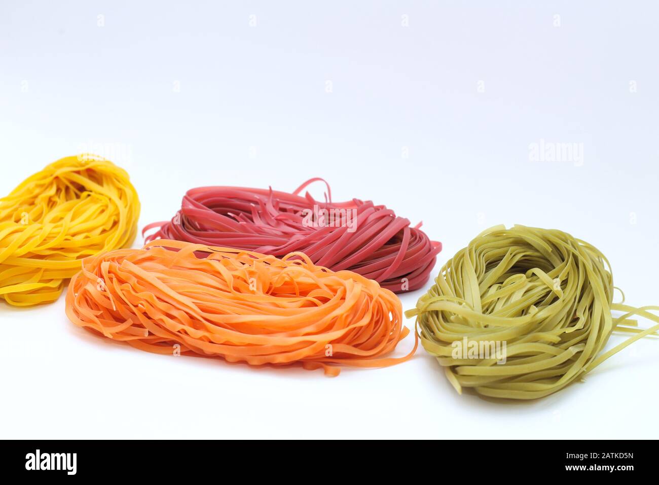 Isolated colored spaghetti nests on a white background Stock Photo - Alamy