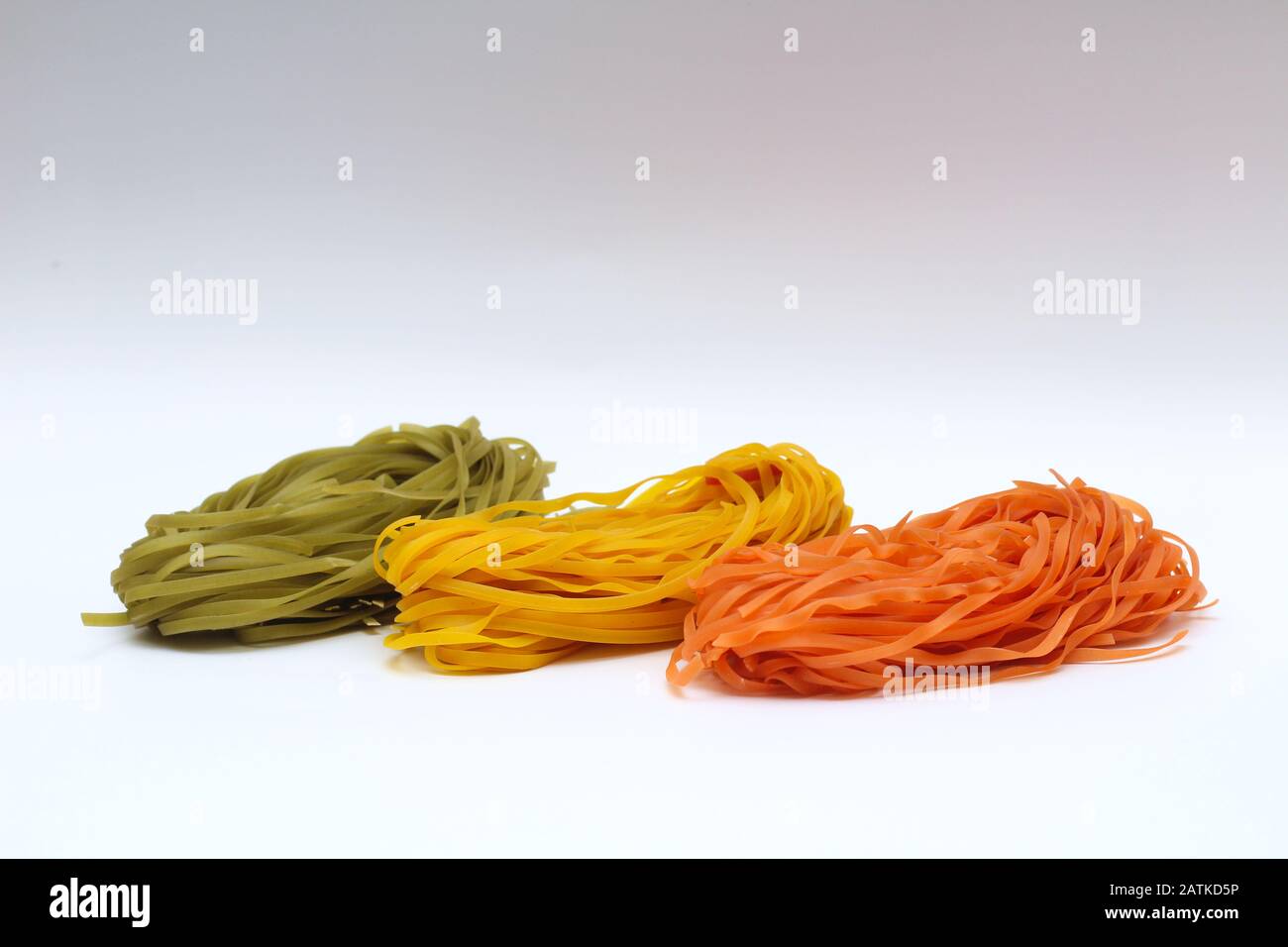 Isolated colored spaghetti nests on a white background Stock Photo - Alamy