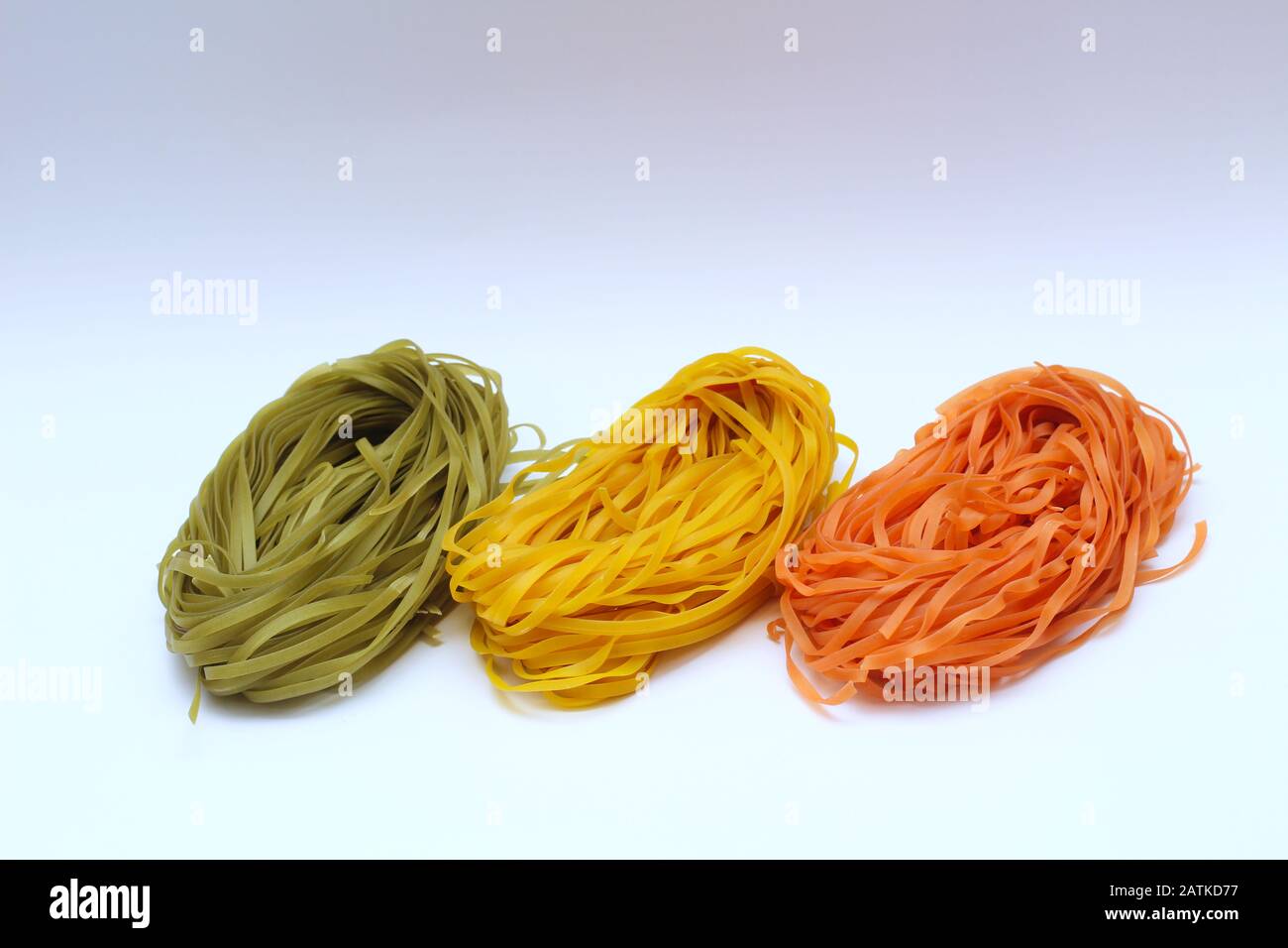 Isolated colored spaghetti nests on a white background Stock Photo - Alamy