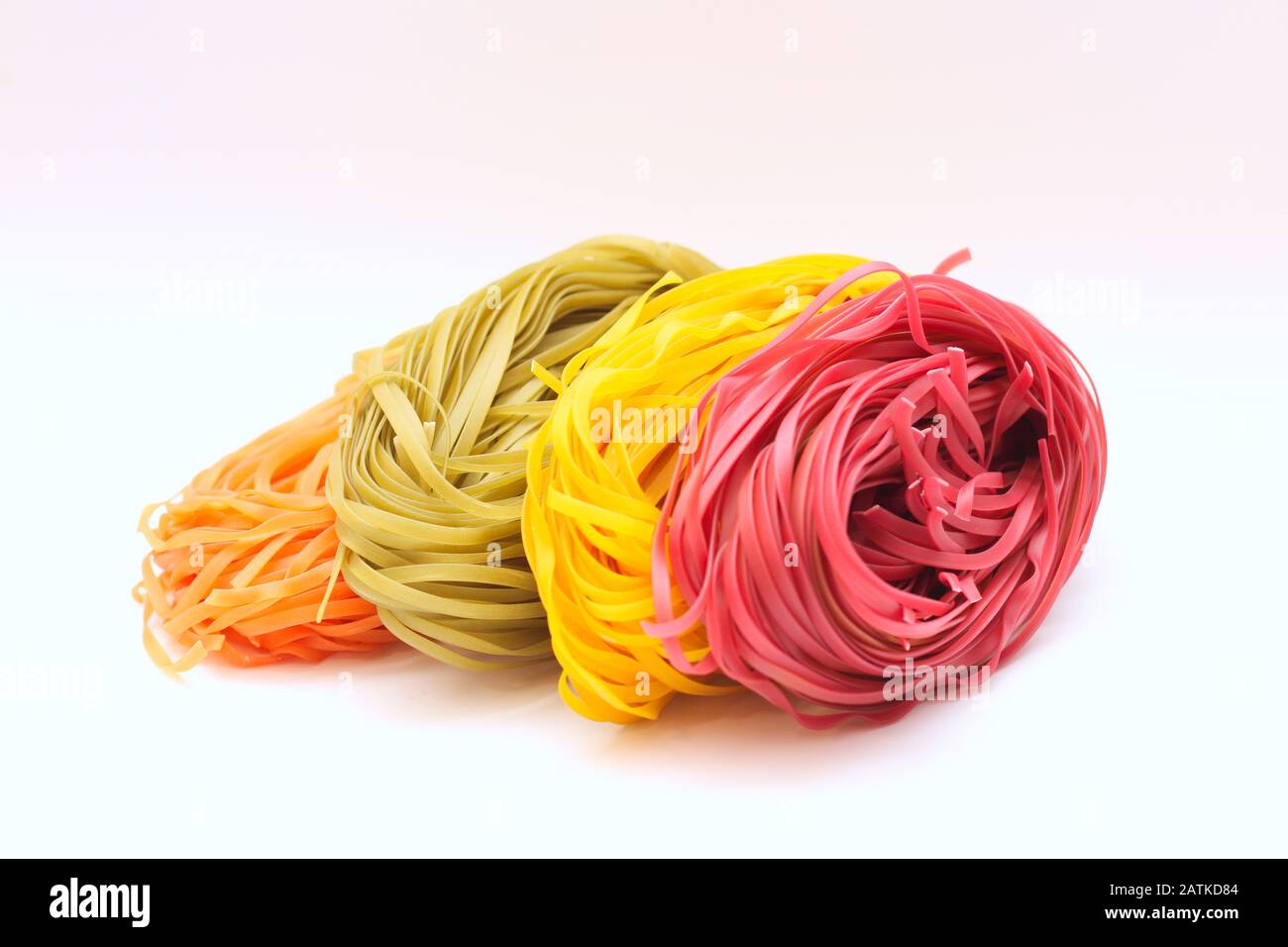 Isolated colored spaghetti nests on a white background Stock Photo - Alamy