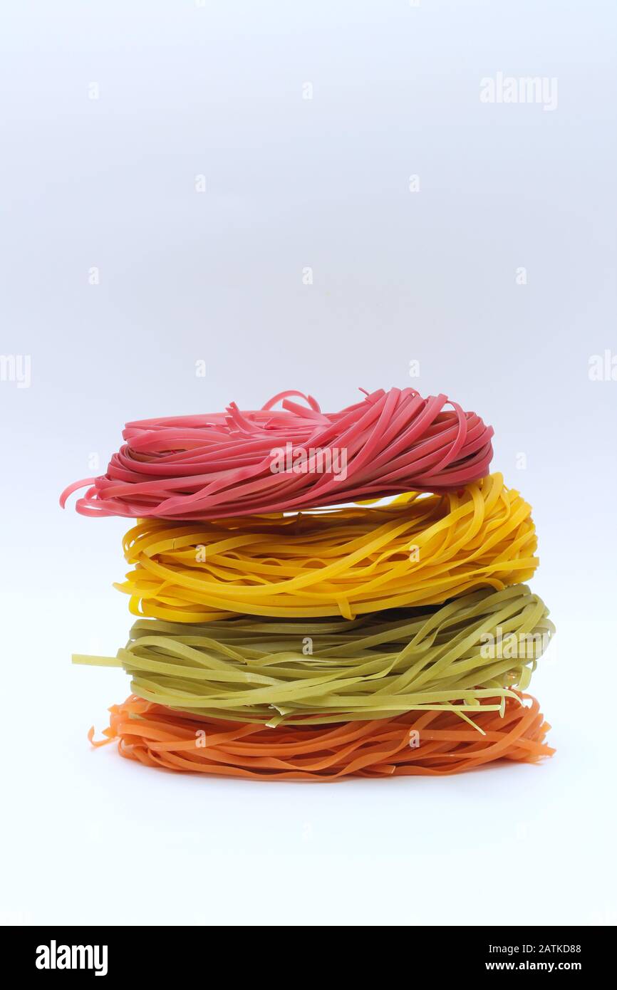 Isolated colored spaghetti nests on a white background Stock Photo - Alamy