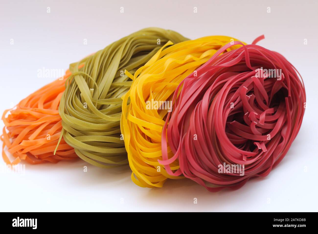 Isolated colored spaghetti nests on a white background Stock Photo - Alamy