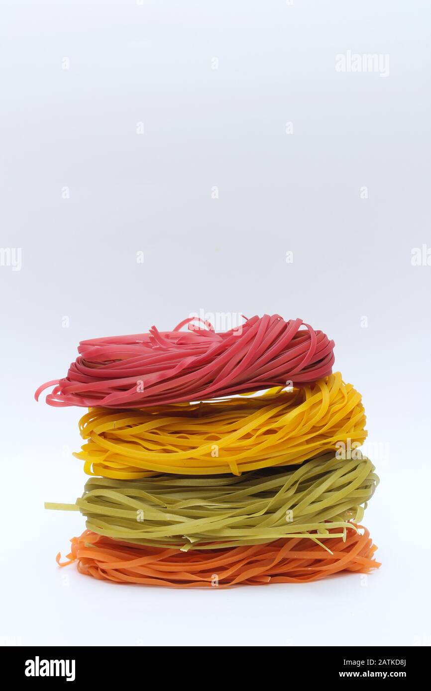 Isolated colored spaghetti nests on a white background Stock Photo - Alamy
