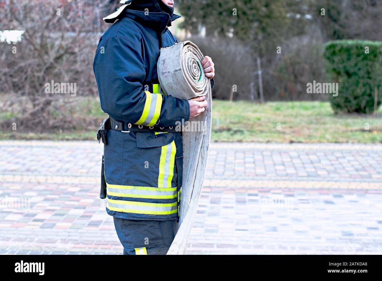 firefighter twists firefighter hose after fire Stock Photo - Alamy