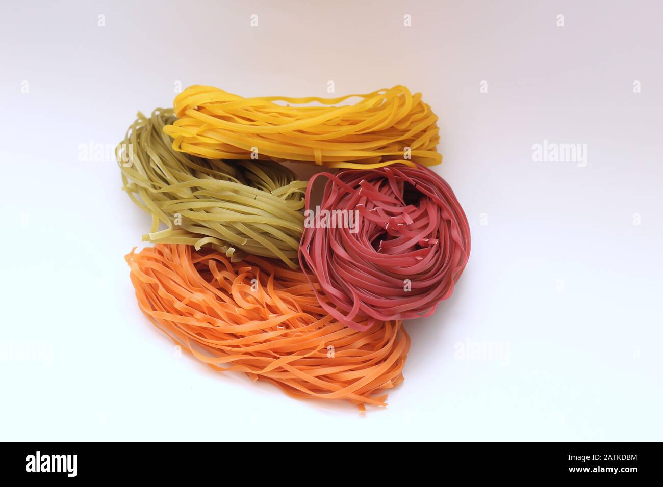 Isolated colored spaghetti nests on a white background Stock Photo - Alamy