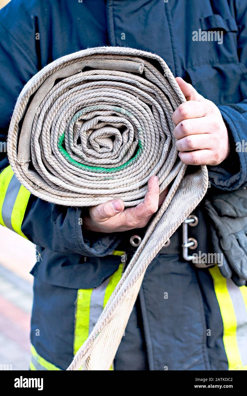 firefighter twists firefighter hose after fire Stock Photo - Alamy