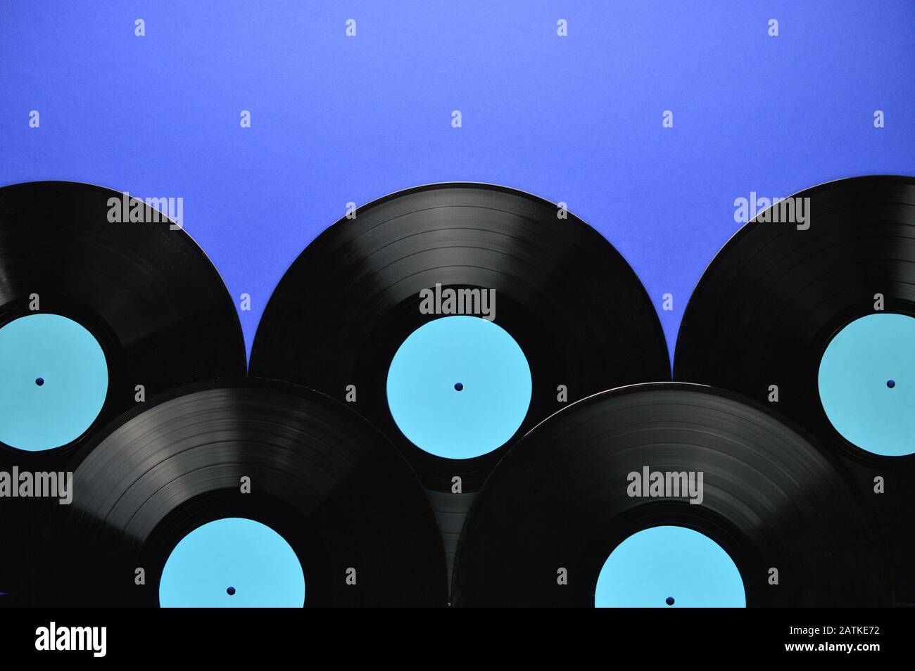 border of old black vinyl records with blank cyan labels on blue ...