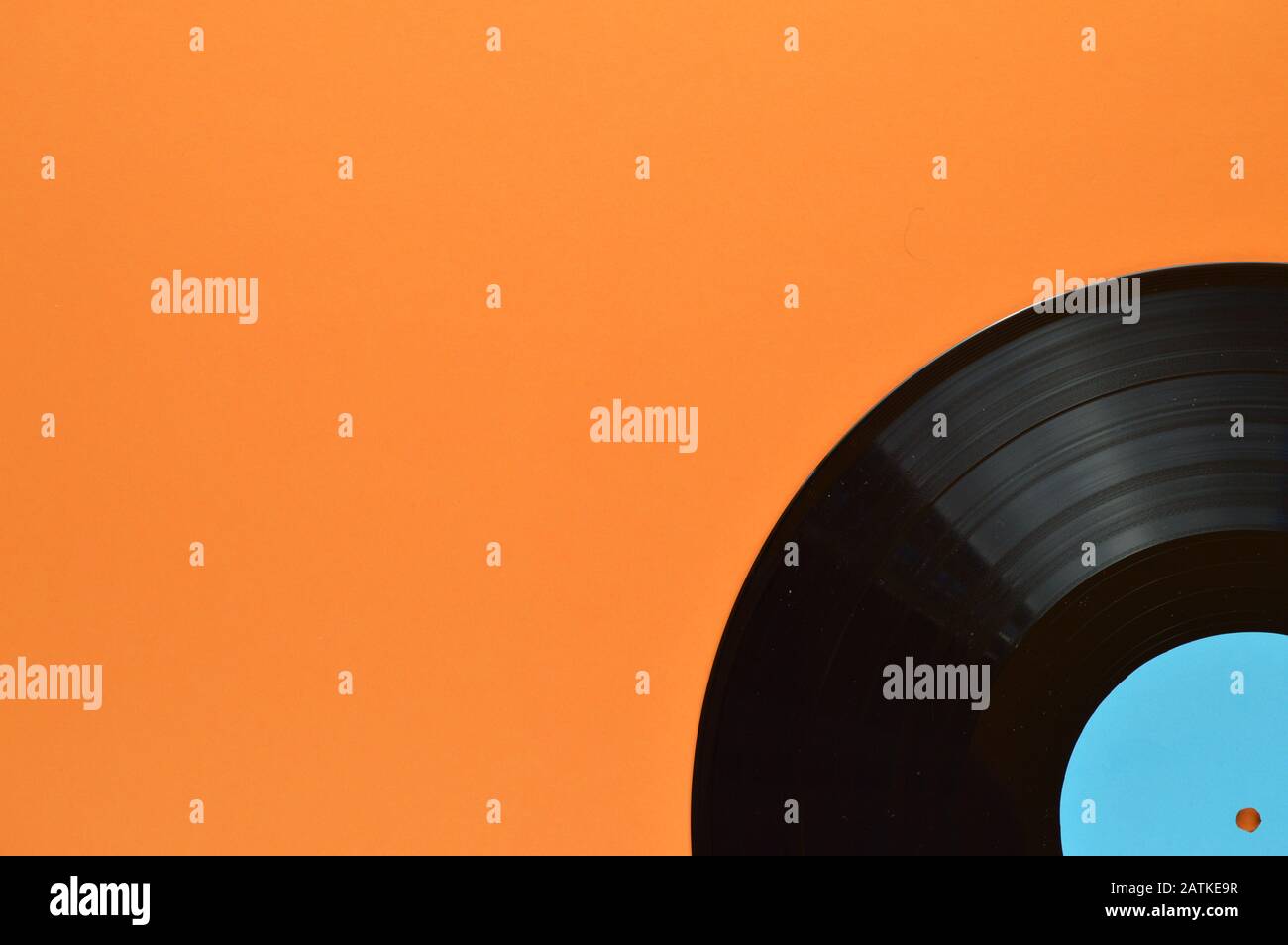 one old black vinyl record with blank cyan label on the edge of orange ...