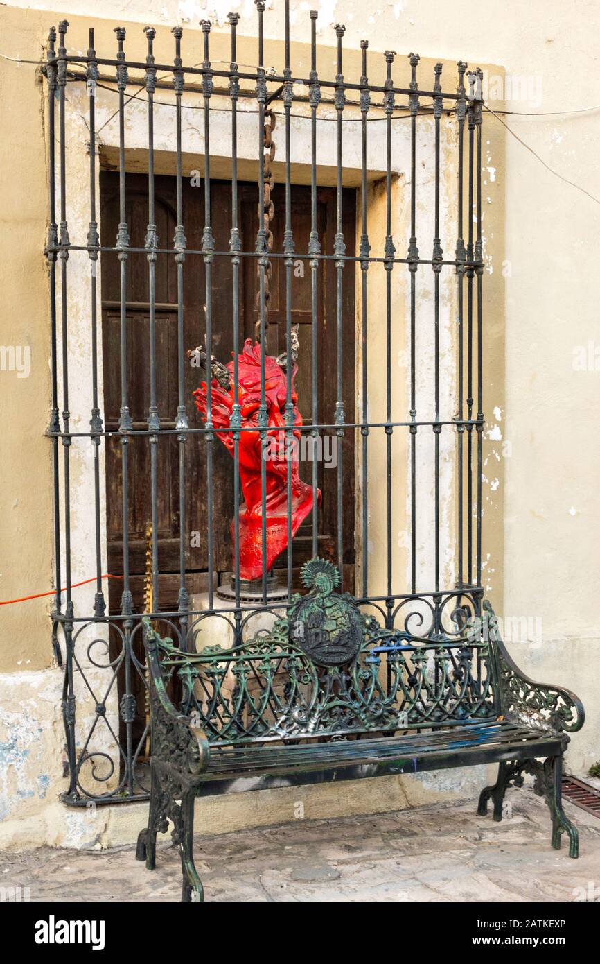 A sculpture of the devil and bench decorate a colonial style building ...