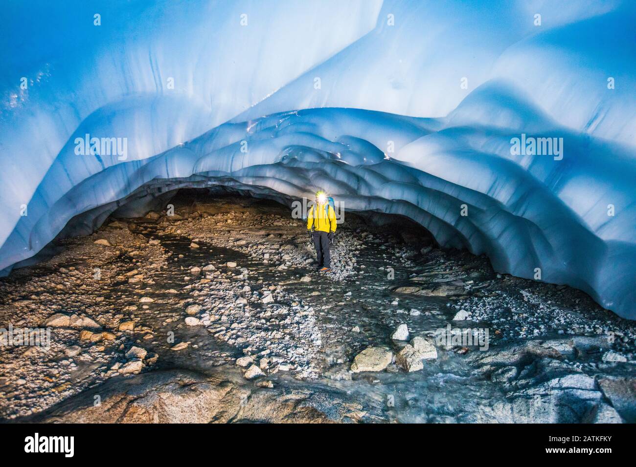 Explorer Standing Under Glacier In Cave Stock Photo Alamy