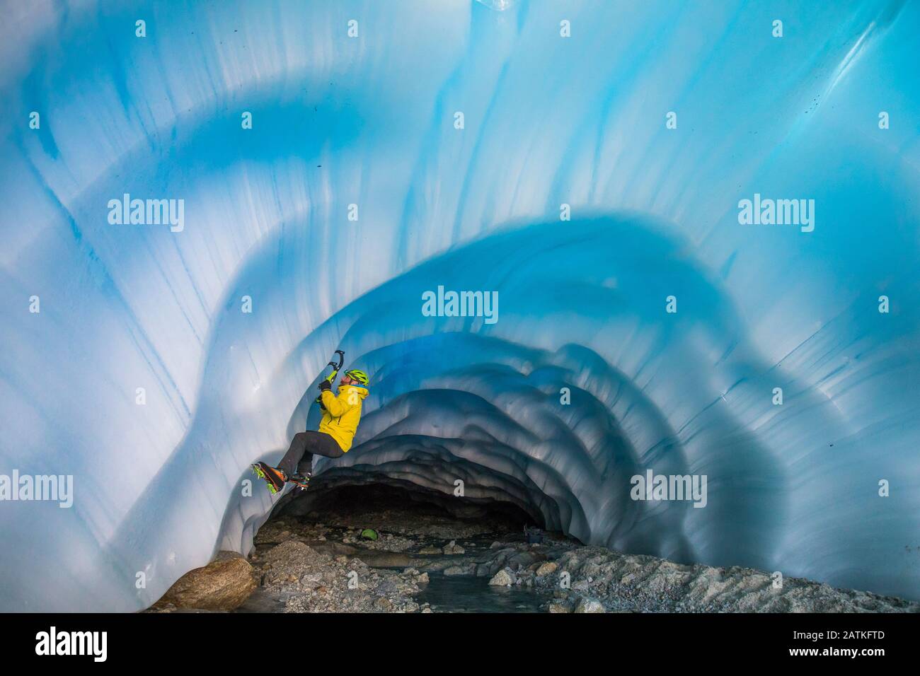 Side view of mountaineer ice climbing in glacial cave Stock Photo - Alamy