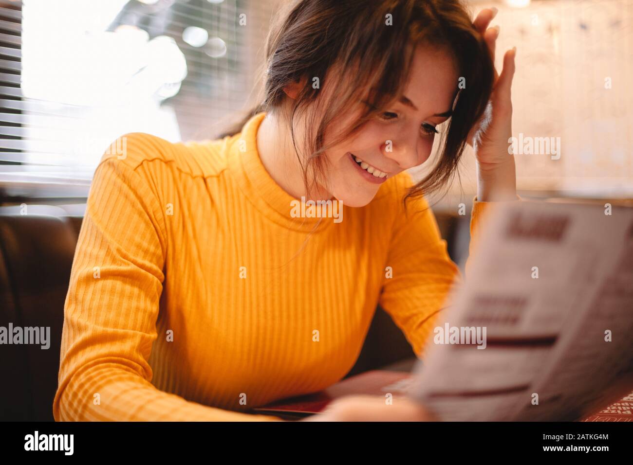 Happy teenage girl reading menu while sitting in restaurant Stock Photo ...