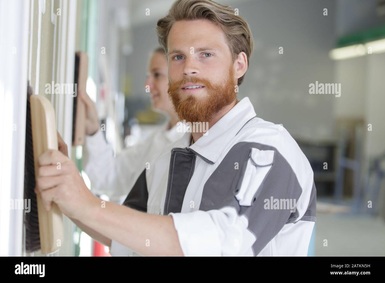 industrial painting apprentice painting the wall white Stock Photo - Alamy