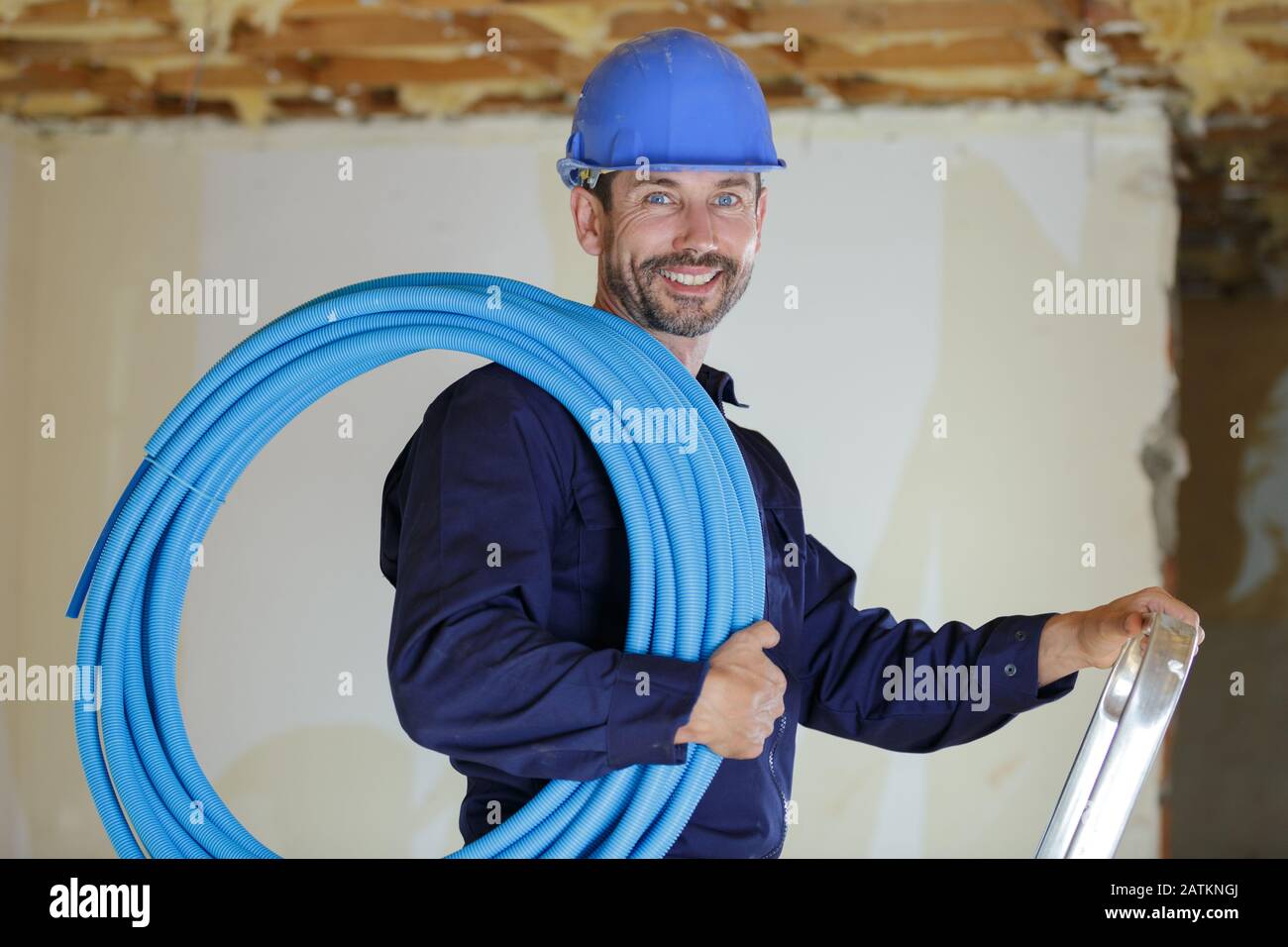 happy plumber standing on ladde Stock Photo - Alamy