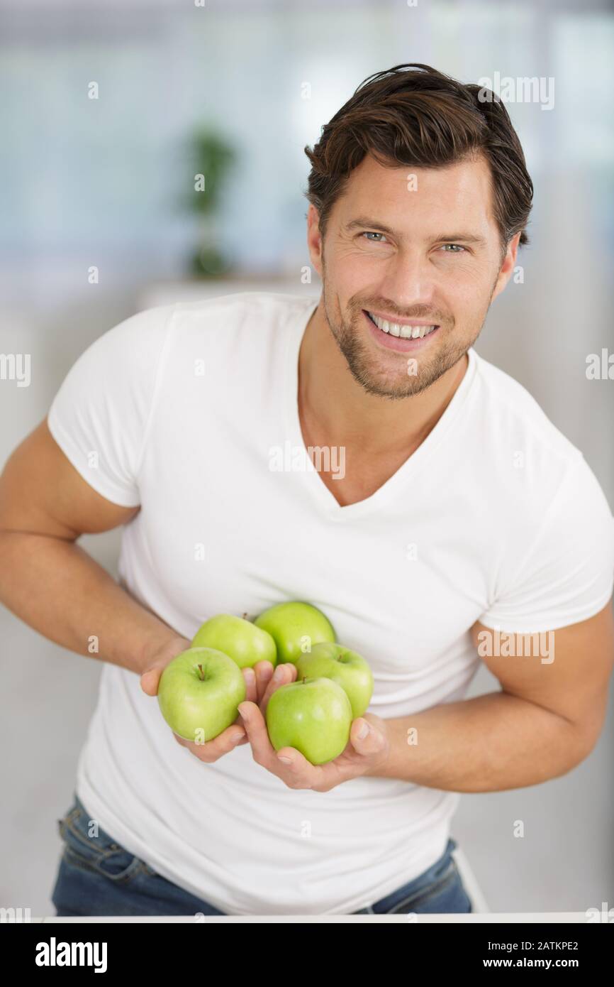 happy and smiling man holding apples in his hand Stock Photo - Alamy