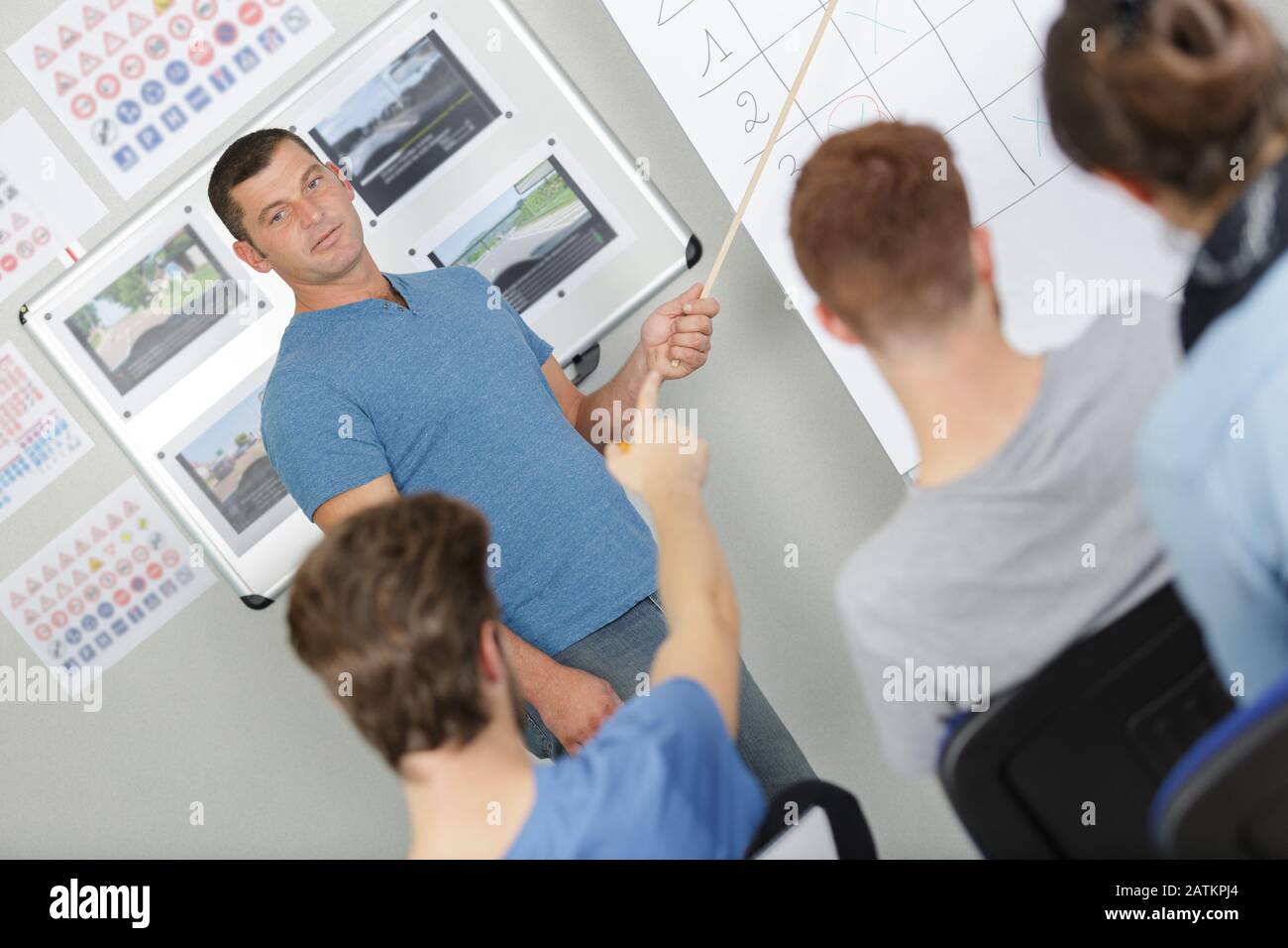 driving instructor pointing at board in a classroom Stock Photo - Alamy