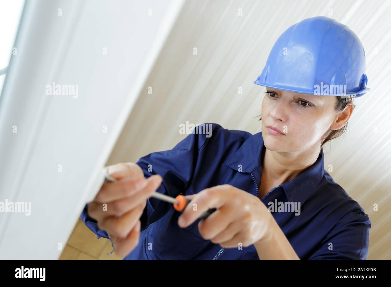 a woman is installing windows Stock Photo - Alamy