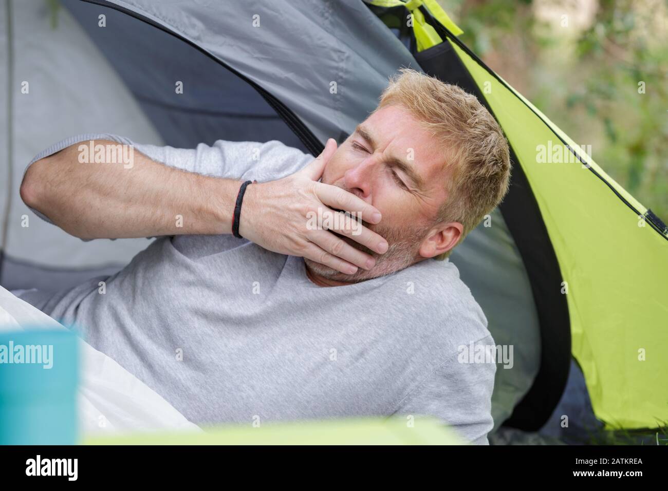 a sleepy man inside tent Stock Photo - Alamy