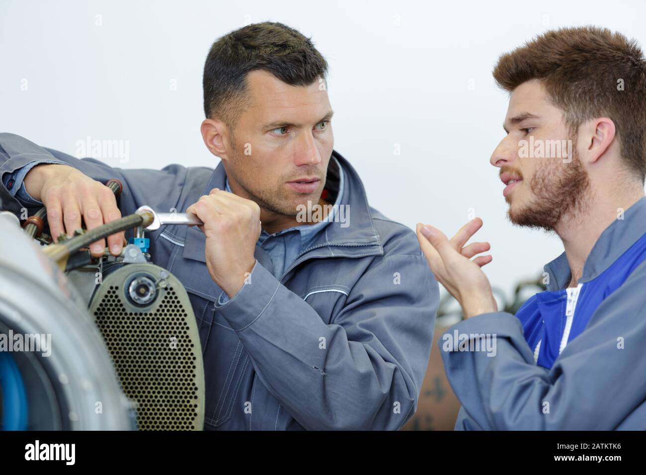 two mechanics working on a car Stock Photo - Alamy