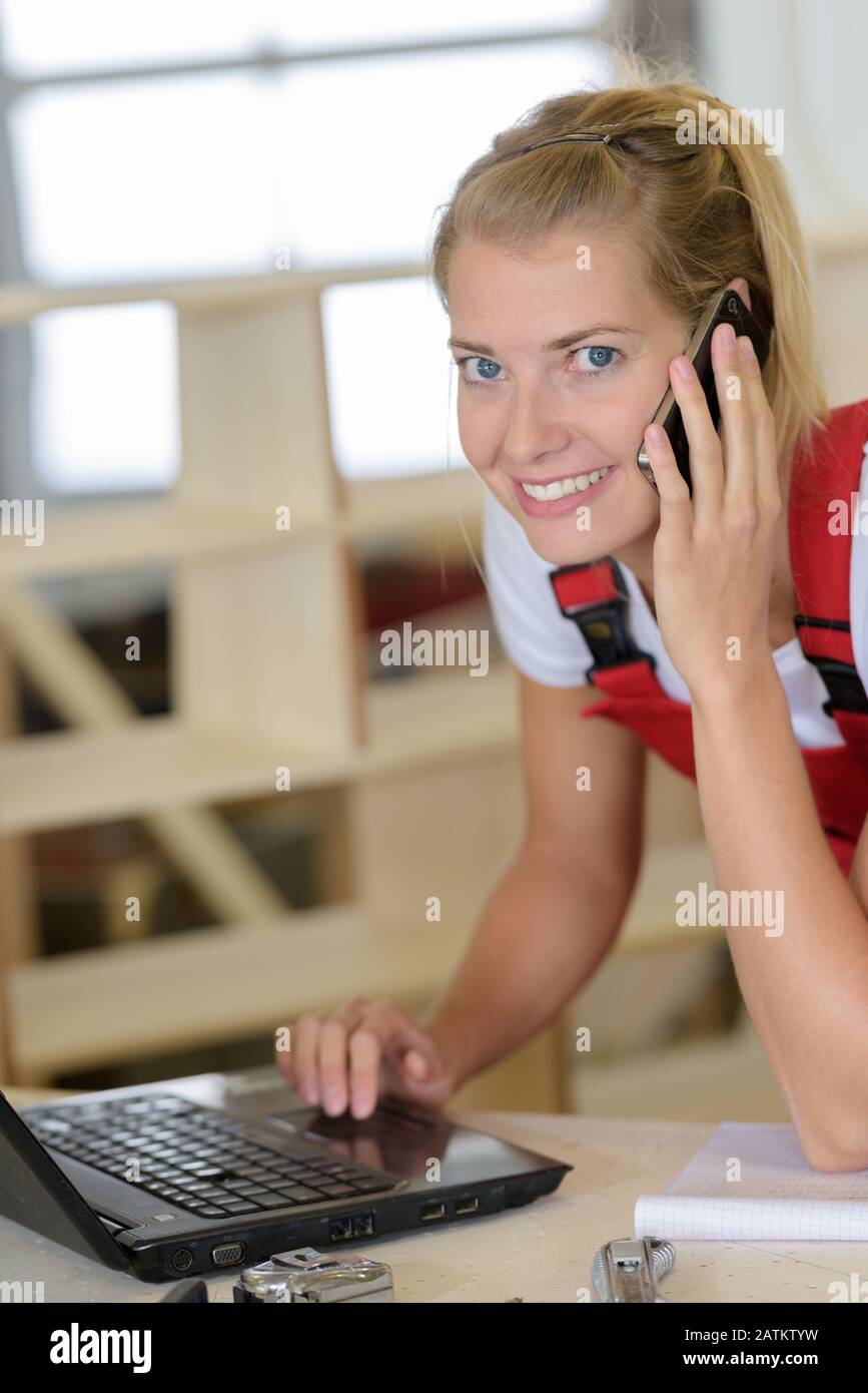 pretty woman speaking on the phone while working in workshop Stock ...