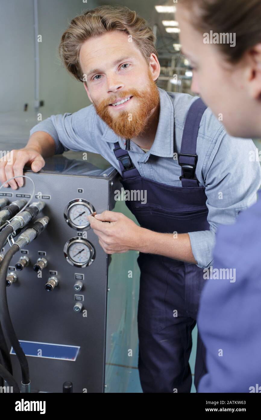 craftsman and colleague turning valve of machine in factory Stock Photo ...